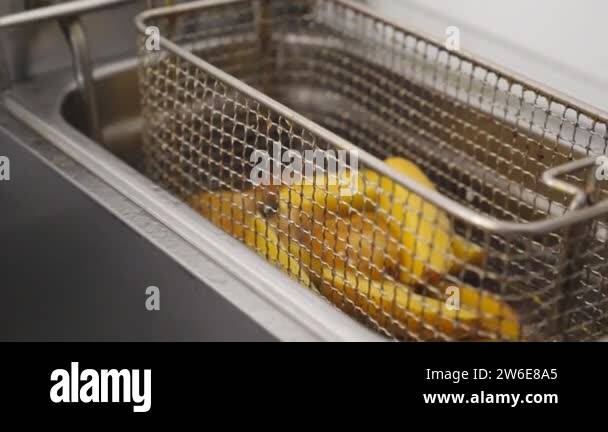 Male cook shaking a lattice with slices of potatoes rustic being ...