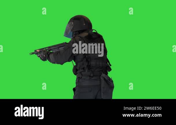 Masked Armed SWAT Police Officer Walking and aiming with rifle on a ...