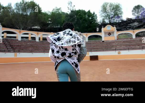 Bullfighter in blue suit of lights slowly bowing in empty bullring ...