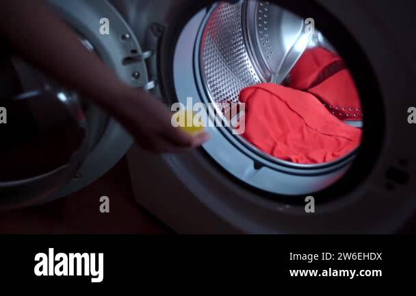 Housewife throwing yellow liquid capsules in slow motion inside the ...