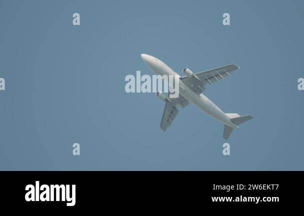 Aeroplane flying in clean blue sky background, bottom view. Action ...
