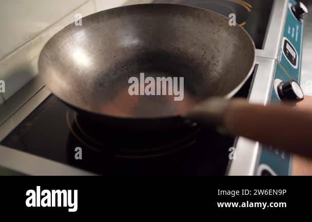 The cook pours sunflower oil into a frying pan, top view. The frying ...