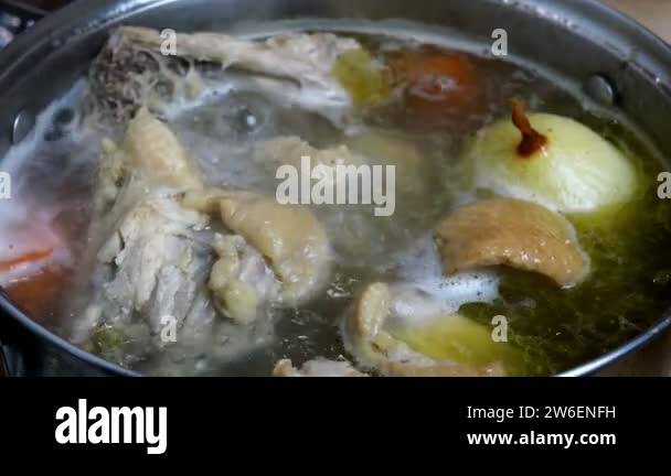 Cooking in boiling water fatty chicken broth from meat and bones with ...