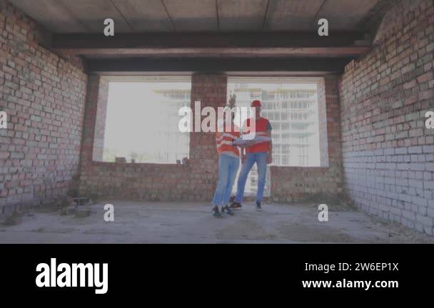 Engineers with a blueprint inside a new house. Builders inside a new ...