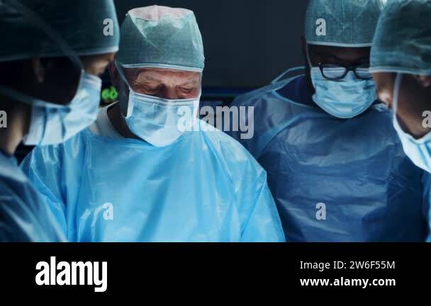 Multiracial team of professional medical surgeons performs the surgical ...