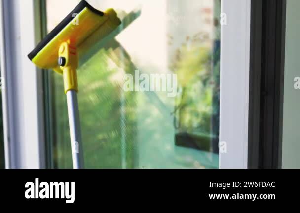 Cleaning the glass window of the house using a mop going up and down ...