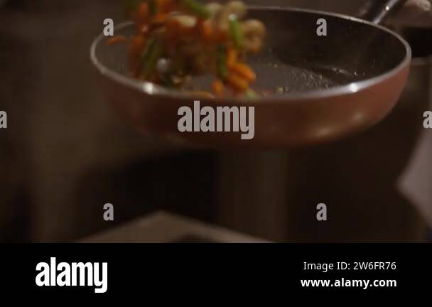 A close video of the frying octopuses with vegetables on a hot pan ...