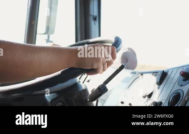 Lorry driver operating the truck through countryside. Trucker holds ...