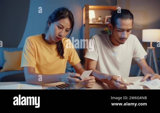 Stress asia couple man and woman use calculator for calculate family budget, debts, expenses ...