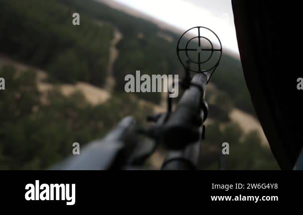 Machine gun with round front sight sticking out of a window of a flying ...