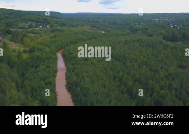 A huge dirty river in the forest. The view from the drone. Clip. A huge ...