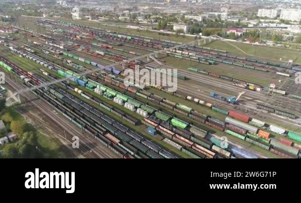 Fly over a large railway junction. Freight trains stand at the railway ...