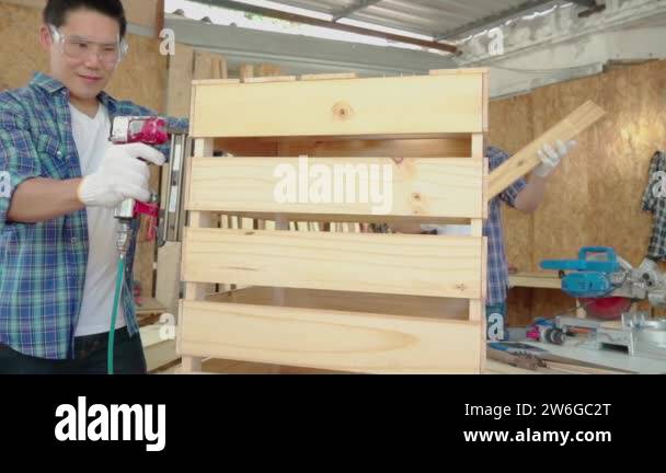 Carpenter standing at workbench with a drill machine. Carpenter using ...