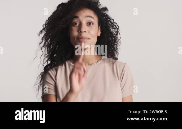 Young cheerful dark fluffy haired Afro woman indicate straightly at ...