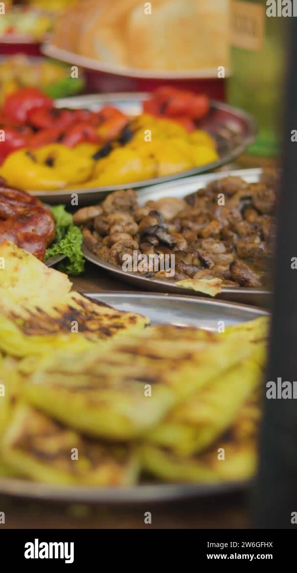 Street food options. Meat dishes and cooked vegetables on the counter ...