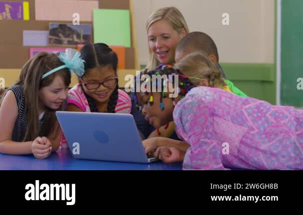 Teacher and group of students use laptop in school classroom Stock ...