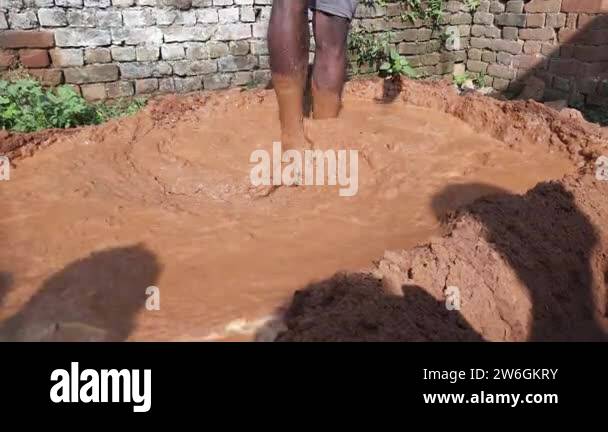 A worker is preparing a clay solution. This clay is used as a mortar ...