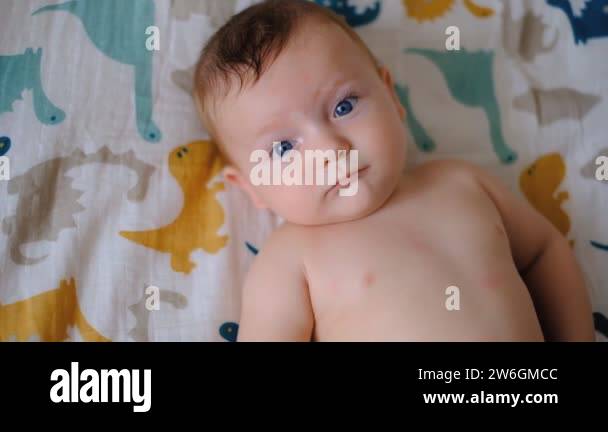 Medical examination of the baby at home. A cute baby lies on his back ...