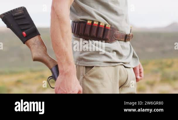 Caucasian male survivalist holding hunting rifle, looking to distance ...