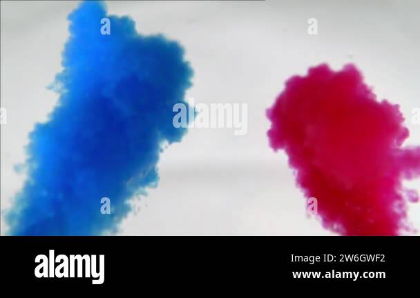Mixing blue and red paint colors in water. Colored smoke effect Stock ...