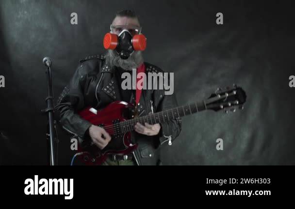 Bearded hairy rocker in transparent glasses, respirator and leather ...