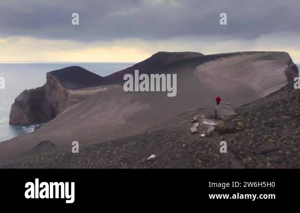 Man running on rocky mountain at Capelinhos Volcano, Faial Island ...