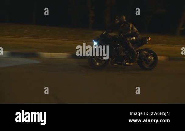 Man riding fast on modern black sport motorbike at evening city street ...