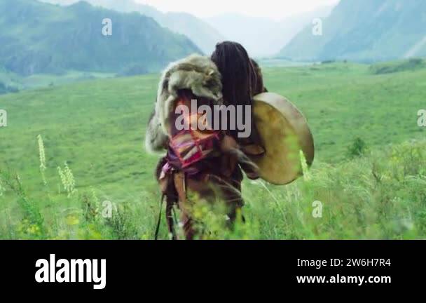 Man in role of Altai shaman in national dress and with wolf skin on his ...