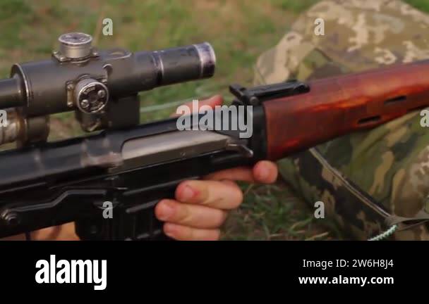 A prone sniper conducts aimed shooting from a sniper rifle with a ...