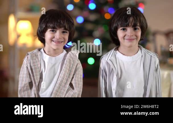 Two happy Middle Eastern twin brothers looking at camera smiling with ...