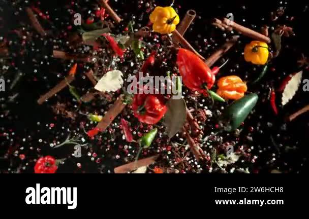 Super slow motion of flying spices mix on black background. Speed ramp ...