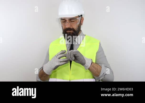 Architect wearing safety helmet and reflective jacket removing gloves ...