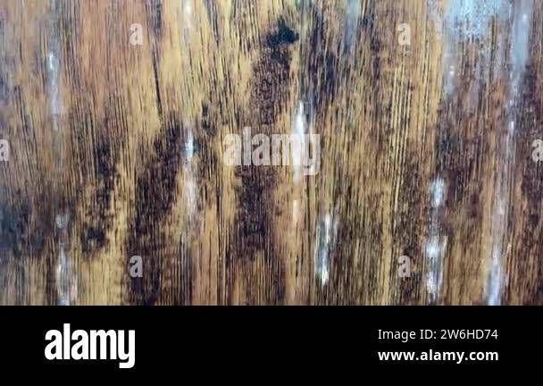 Water flows in a stream over the surface of the laminate, wooden ...