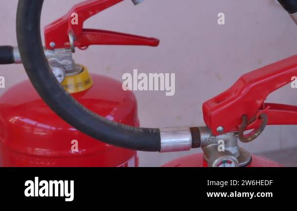 sliding close-up of two fire extinguishers with valves and pressure ...