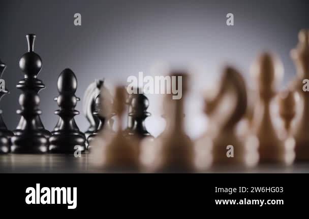 rotating chessboard with lines of white and black wooden chess figures ...