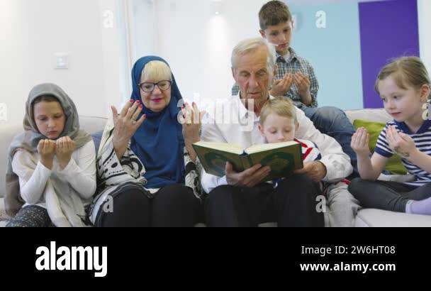 Traditional muslim family grand parents with children reading Quran and ...