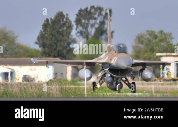 Military airplane stopped on the runway with the jet engine running ...