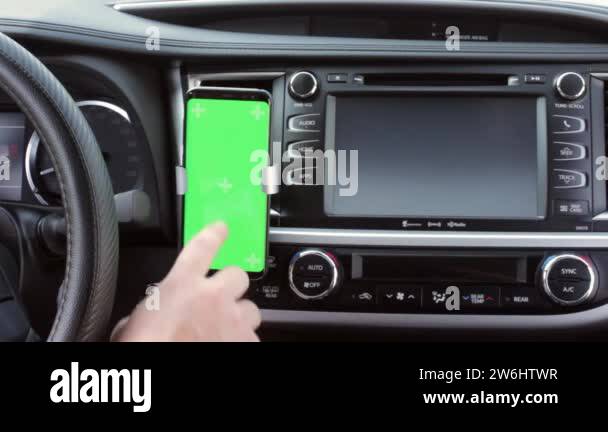 Closeup of green screen smartphone on dashboard car panel. Navigating ...