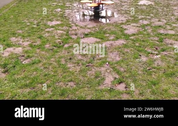 Puddles on a wet playground after rainy day in a forest shows lonely ...