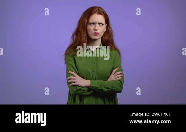Offended woman keeping arms crossed, feeling mad at someone on violet ...