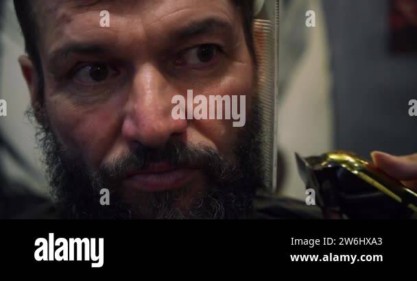 Professional barber shaves customer beard with straight razor. Beard ...