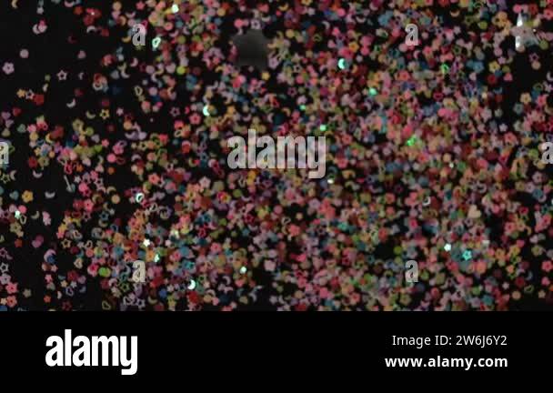 Close up Confetti explosion on black background. Slow Motion confetti falling video. Multi color ...