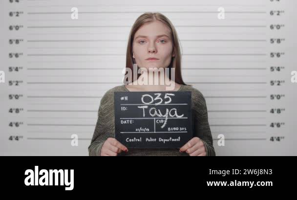 Mugshot of millennial arrested woman holding sign while being ...