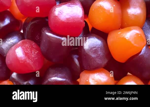 Close-up texture of red, orange and purple multivitamin gummies on ...