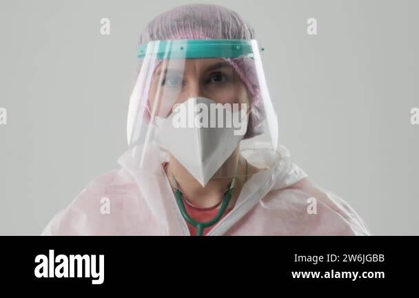 Portrait of female medical worker with face mask and shield. EMS ...