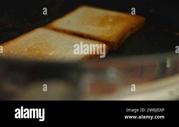 Two slices of toasts cooked in a pan on the stove. Cooking delicious ...