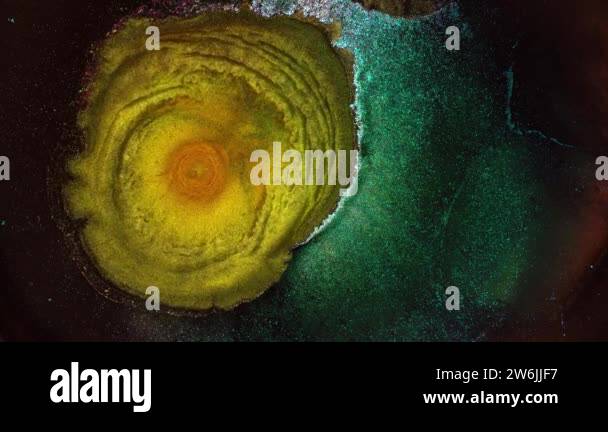 Metallic gold and green liquid ink macro. Abstract explosive light ...