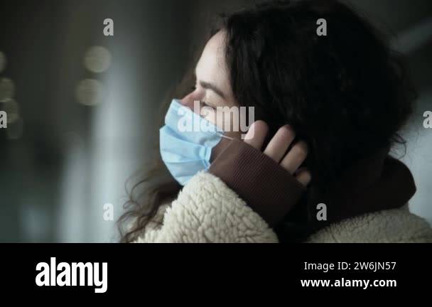 portrait of 25s woman taking off a medical mask from her face. The girl ...