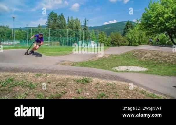 Young Boy Riding a Razor Kick Scooter at an Outdoor Skate Park ...