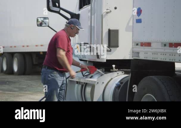 Truck driver filling up fuel tank of semi truck. Fully released for ...